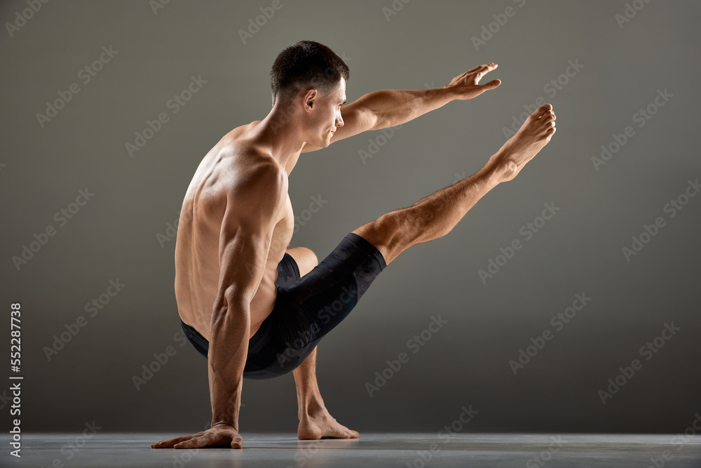 Portrait of male flexible muscular athlete showing animal flow sport ...