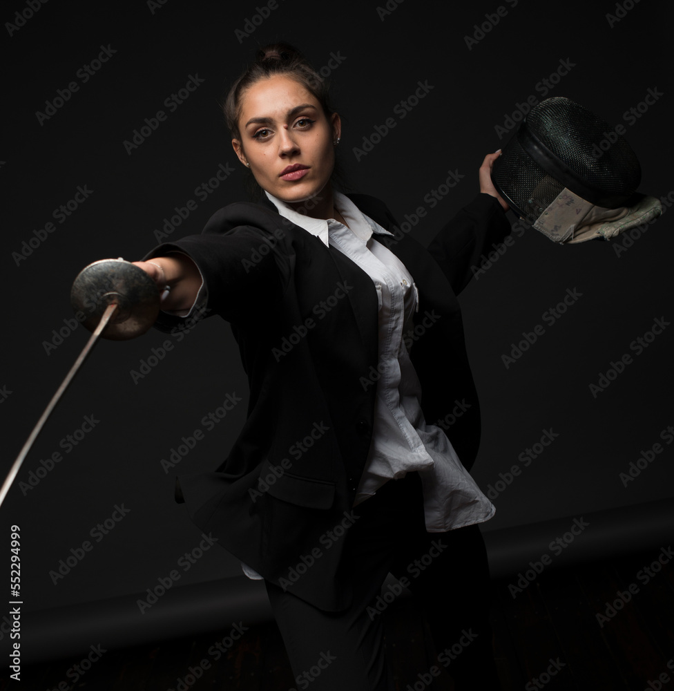 portrait of a young woman in a dark suit with a rapier and a mask ...
