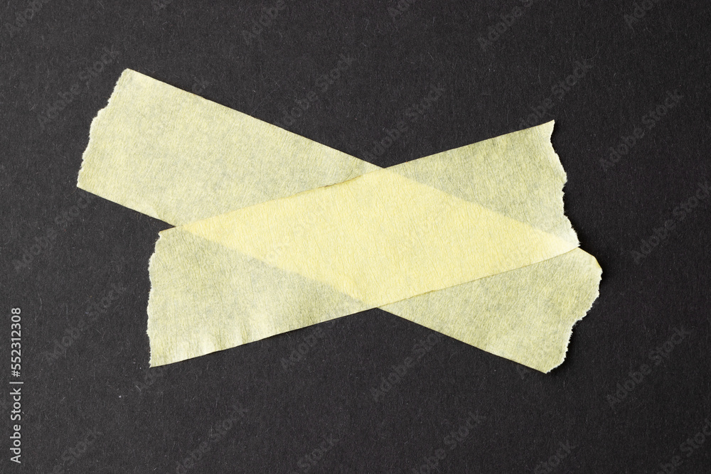 Ripped up pieces of masking tape with copy space on black background ...