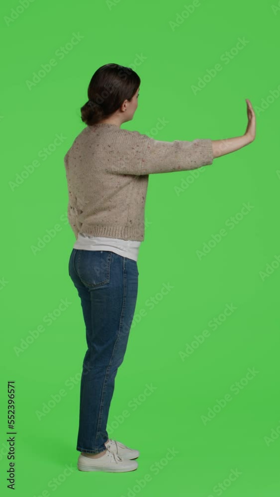 Vertical video: Profile of female model showing palm over greenscreen ...