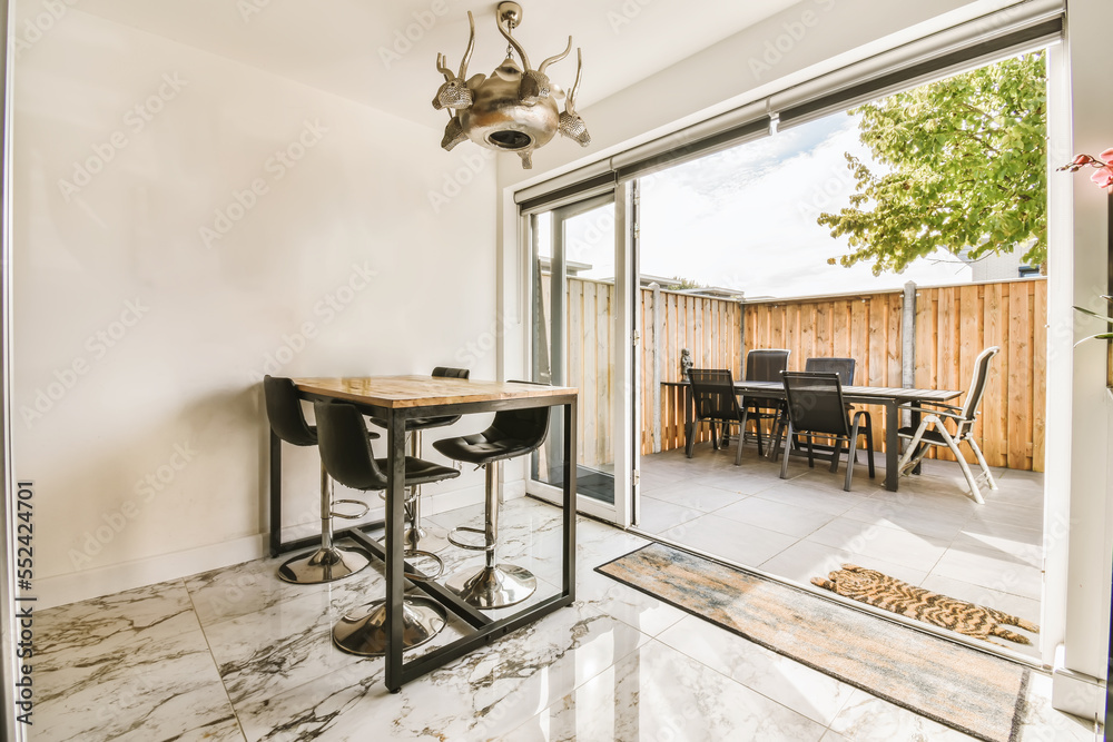 an outside area with a table and bar stools on the floor in front of a ...