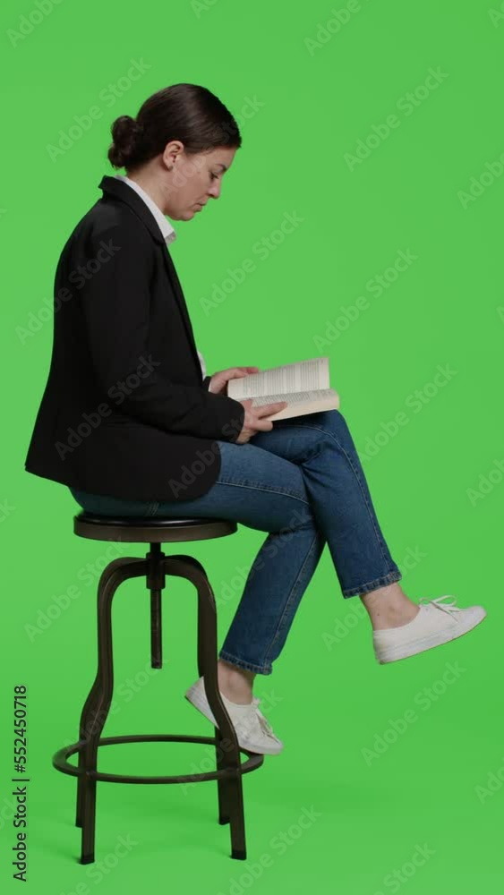 Vertical video: Profile of focused businesswoman reading book sitting ...