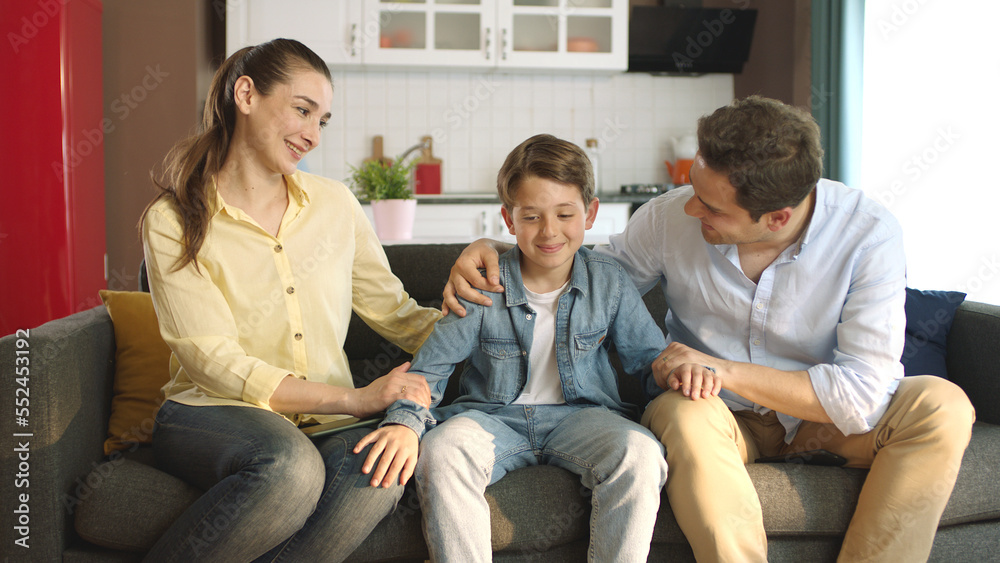 Smiling family resting on sofa and talking to each other. Happy ...