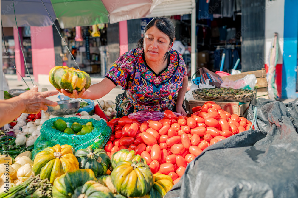 Vendedora indigena en un puesto de vegetales en un mercado de Guatemala ...