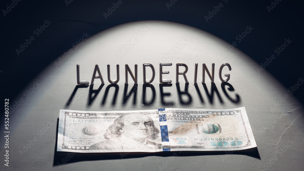 Money laundering concept. Money and the word laundering in a spot of ...