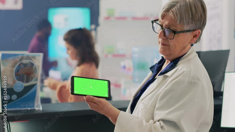 Pharmacy worker showing smartphone with greenscreen display, holding ...
