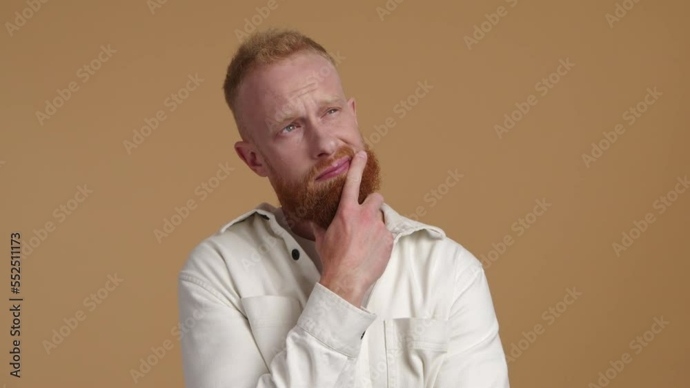 Annoyed guy touching his chin while overthinking. Close-up view of a ...