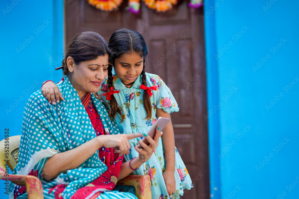indian rural woman and his little daughter using smartphone. Stock ...