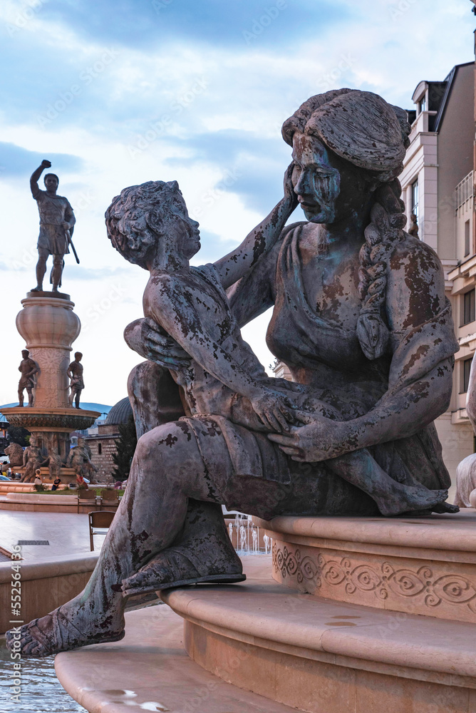 Statua matki i syna i pomnik Filipa II Macedońskiego za plecami. Skopje ...