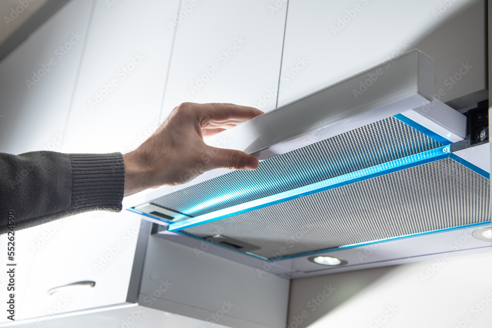 Male hand using cooker hood in modern kitchen. Stock Photo | Adobe Stock