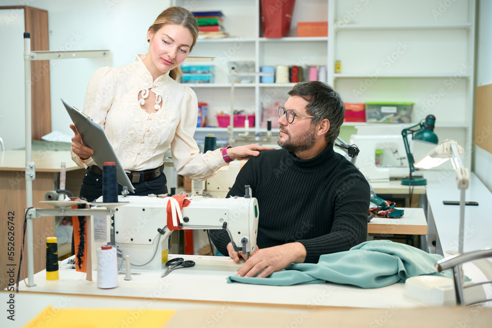 Beautiful woman stands at the table with a sewing machine Stock Photo ...