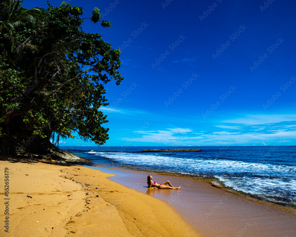 beautiful girl in a bikini lies on the sand on a Caribbean beach in ...