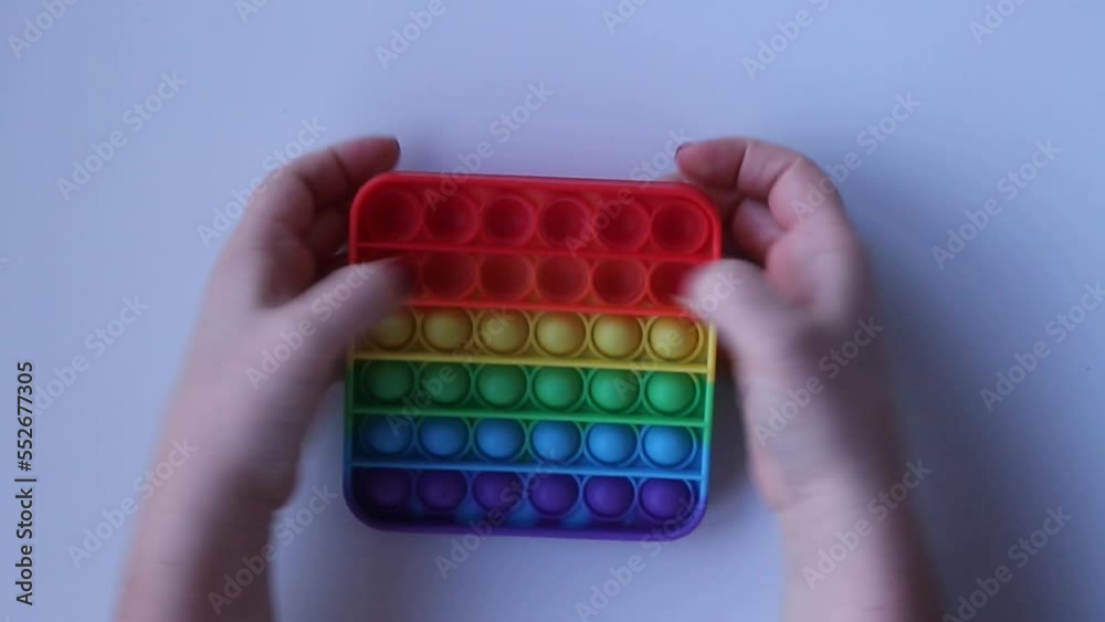 Women hands crumple and play with large Square Pop It close-up top view ...