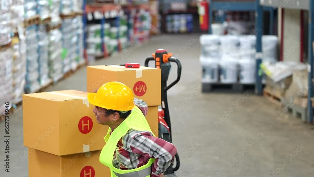 Worker with back pain while lifting boxes in a warehouse. Pain, fatigue ...