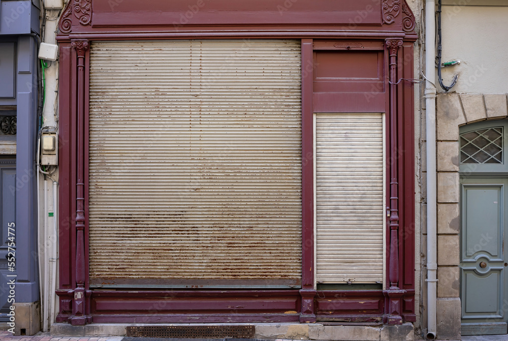 Frontal view of a closed shop in the old town. The metal roller shutter ...