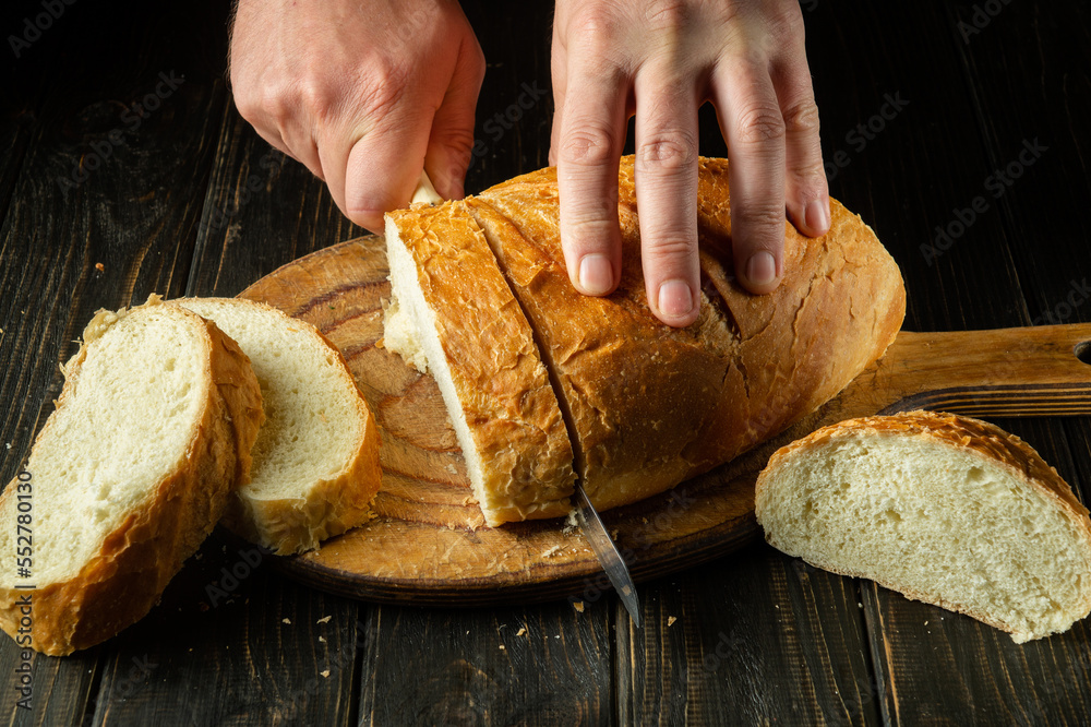 Foto de Whole grain bread put on kitchen wood board with a chef holding ...
