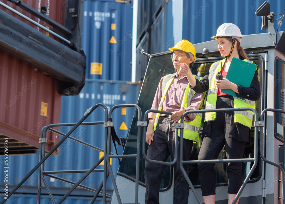 Reach stacker truck lifting heavy cargo box in container yard. Female ...