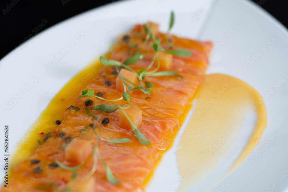 salmon fileteado crudo con salsa agridulce de maracuya en un plato ...