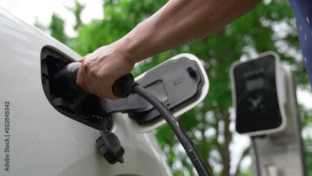 Progressive man install power cable plug to his electric vehicle, EV ...