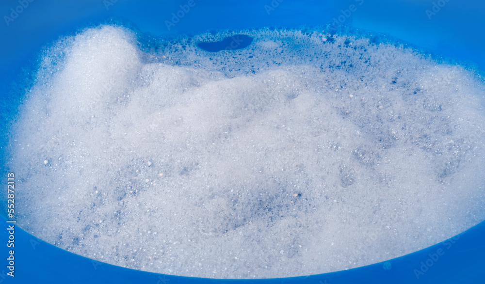 white foam in a blue bathroom close-up. foam in a blue basin. Blue ...