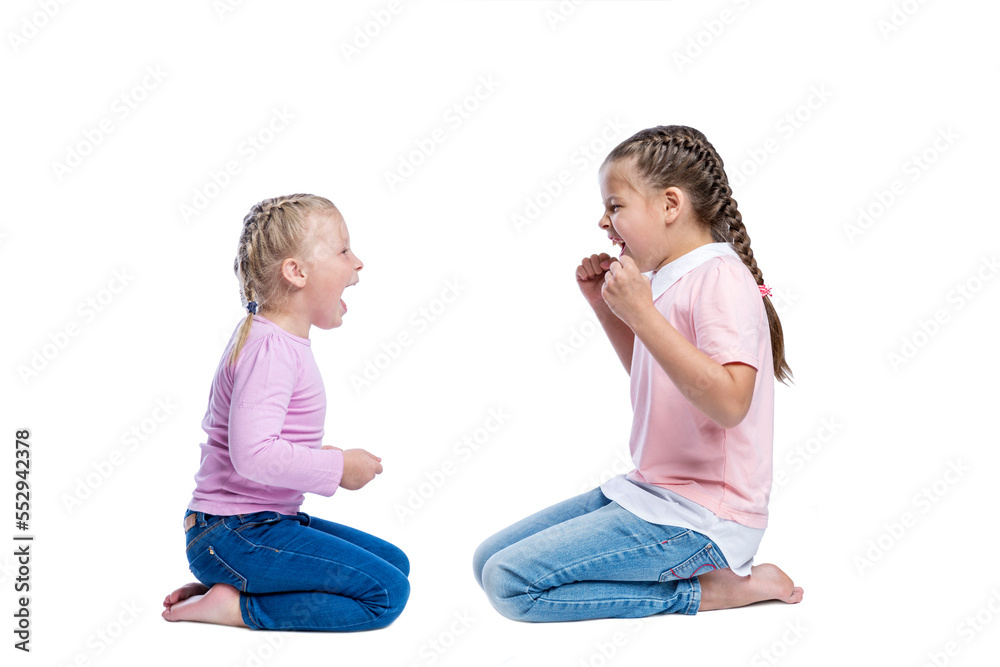 Two little girls are sitting and yelling at each other. Children in ...