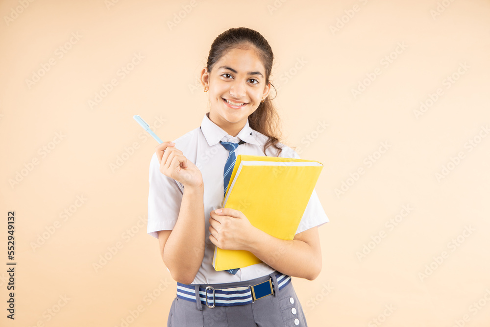 Happy Indian student schoolgirl wearing school uniform holding books ...