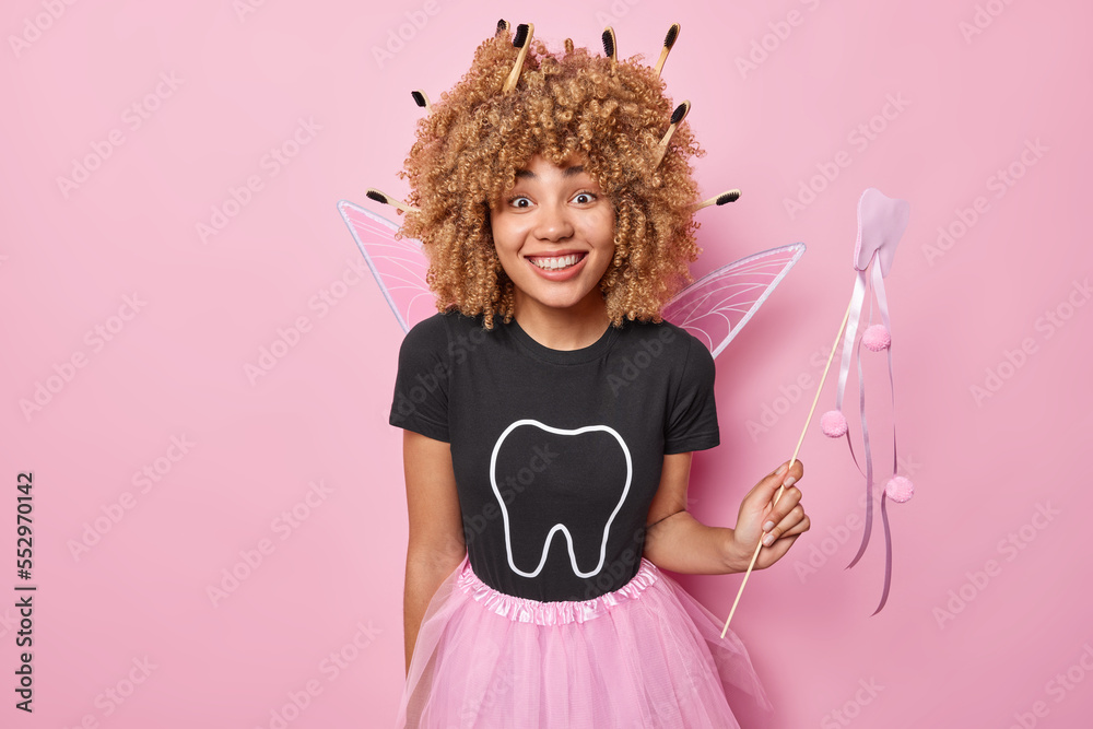 Horizontal shot of curly haired female tooth fairy wears black t shirt ...