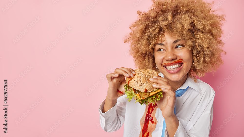 Horizontal shot of happy female model with curly hair smiles broadly ...