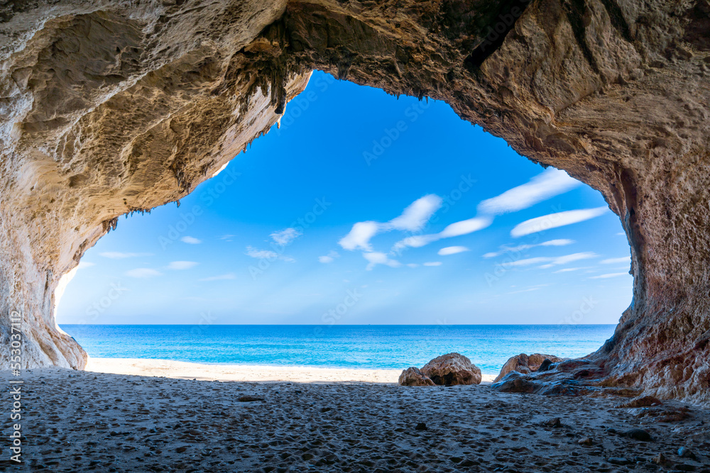 view out of one of the many seaside caves at the beach of Cala Luna in ...