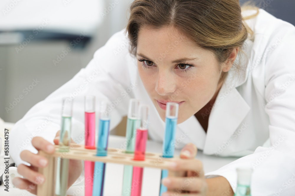young chemistry teacher in school laboratory workplace looking at test ...