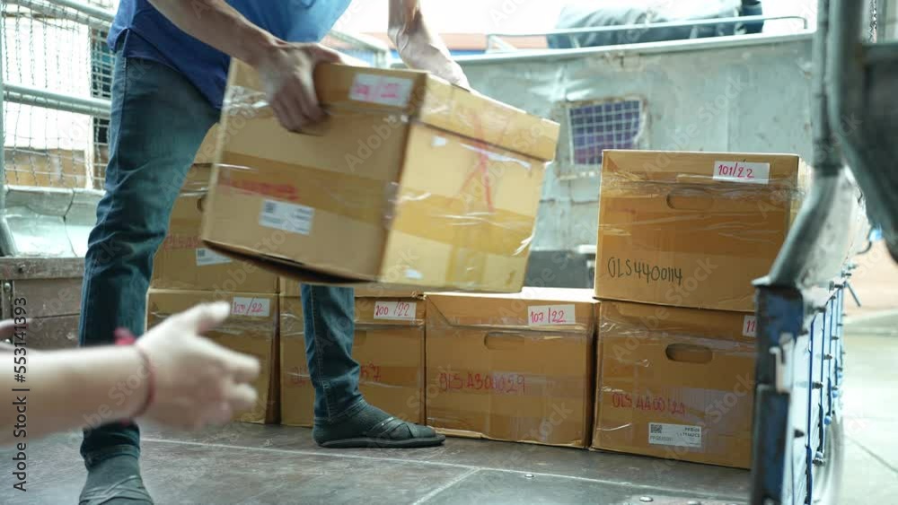 Man unloading cardboard boxes for storing documents from the trunk of ...