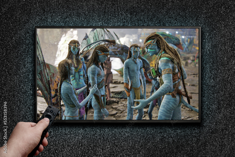 Man turns on TV with remote control. TV screen playing Avatar the way ...