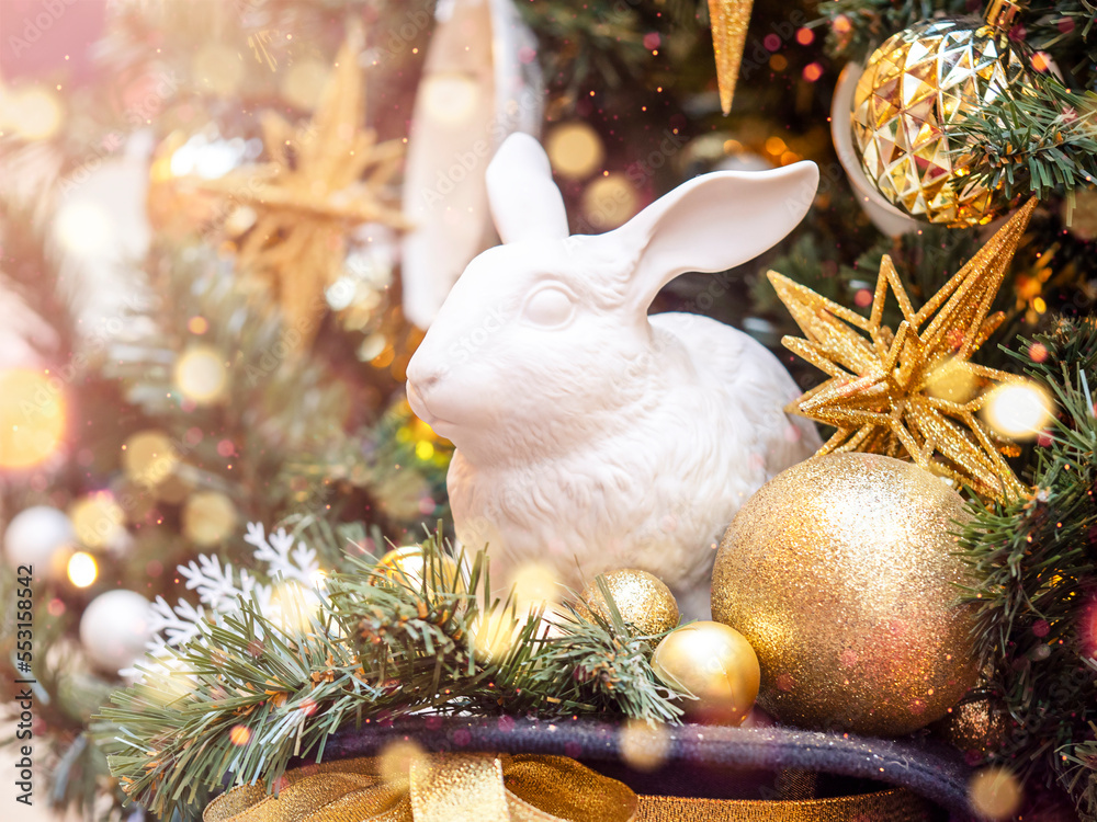 Figurine of a ceramic rabbit with balloons under the tree. A symbol of ...