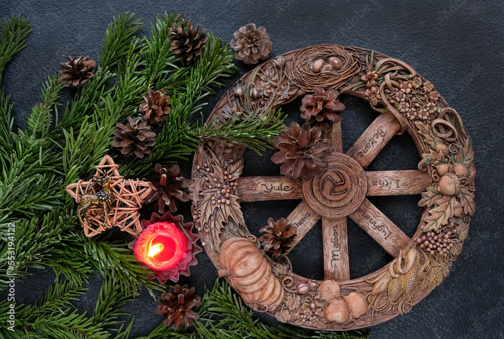 wiccan altar with Wheel of the year candle, amulet deer, cones, fir ...