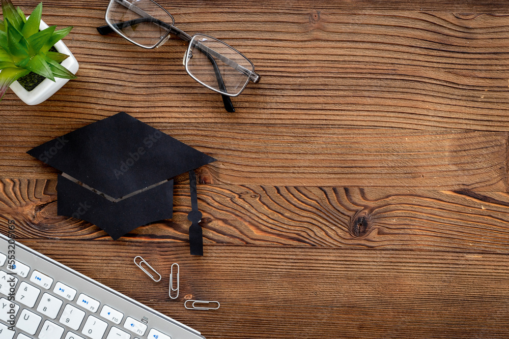 Black academic cap or graduation hat on students table, top view Stock ...