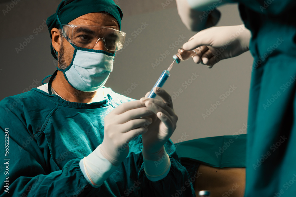 Surgeon fill syringe from medical vial for surgical procedure at ...