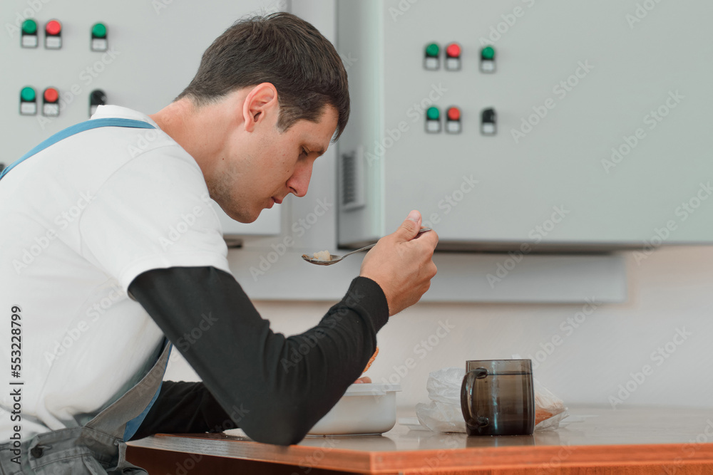 Lunch break. Eating in workplace during work. Caucasian man in work ...
