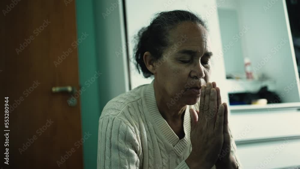 One hispanic black woman praying at home. Spiritual elder lady prays ...