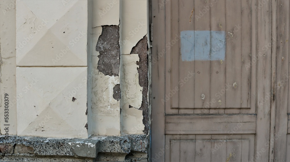 cracked and flaky corner of a city building with cracks and wooden old ...