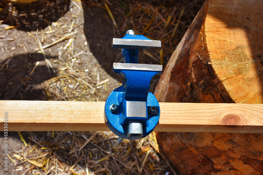 Carpenter's tools on wooden plank, iron vise in work area. iron vise ...