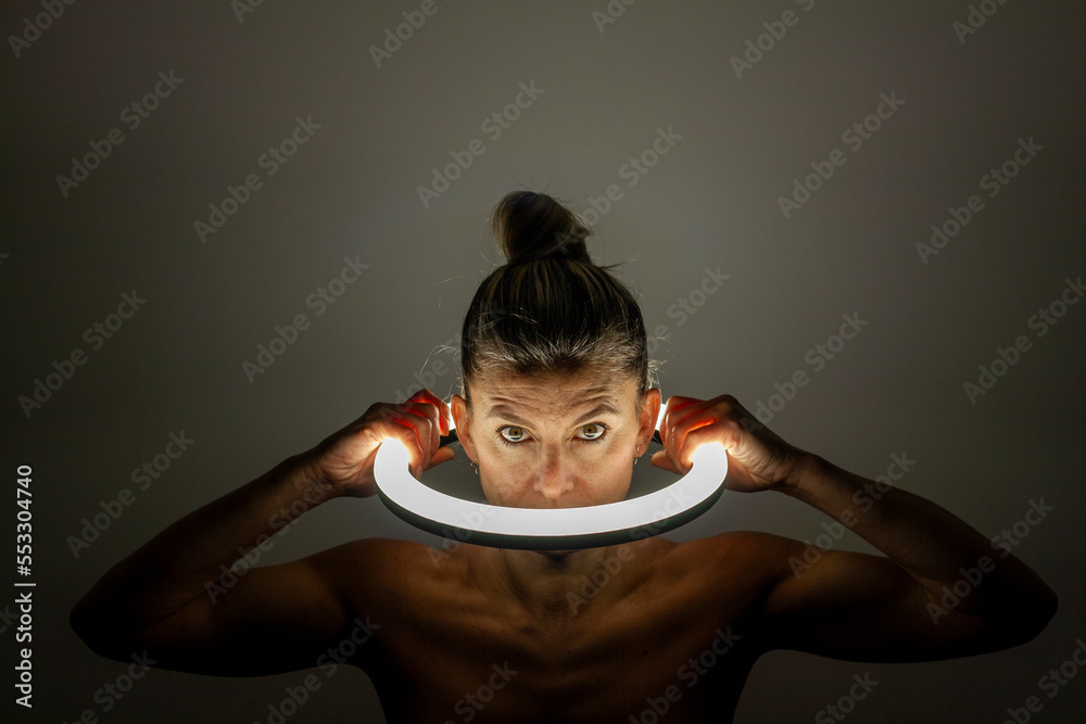 Blonde woman without clothes, only with a light ring showing her ...