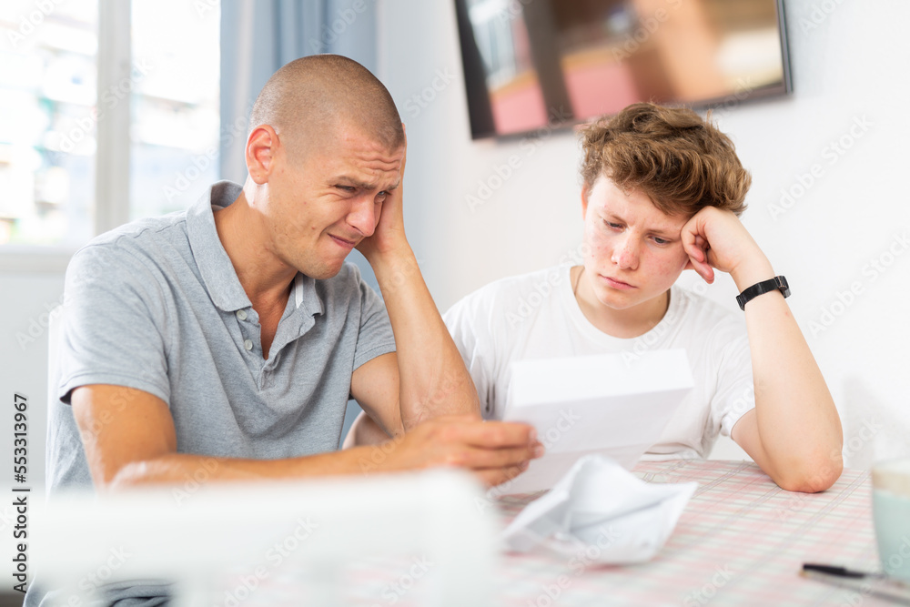 Father and son have recieved letter and reading it. They feeling ...