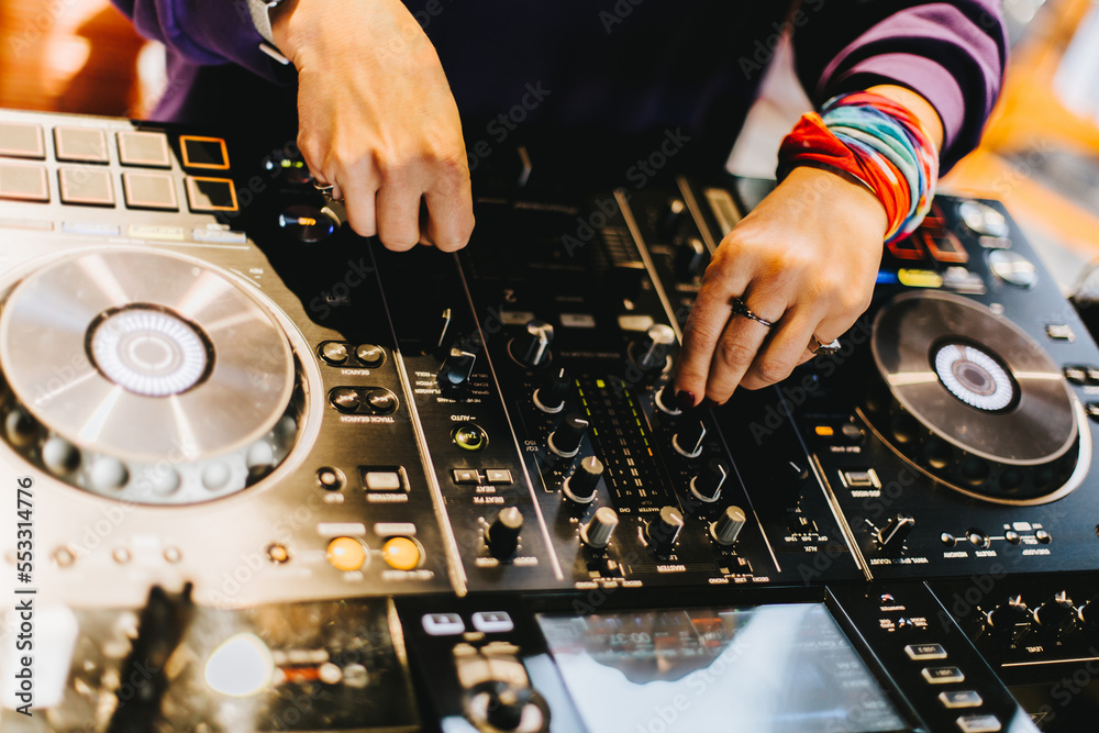 DJ plays live set and mixing music on turntable console on stage at ...