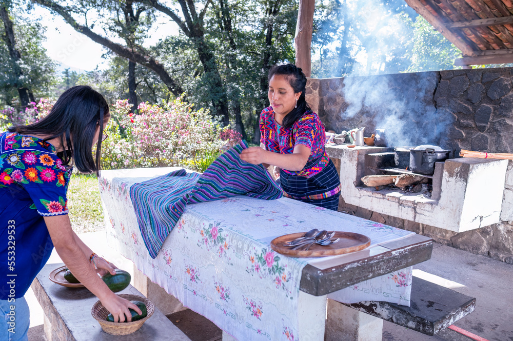 Foto de Madre e hija poniendo la mesa para comer. Familia indigena en ...