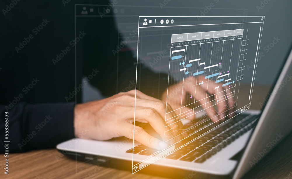 Foto Stock Project manager working on laptop and updating tasks and ...