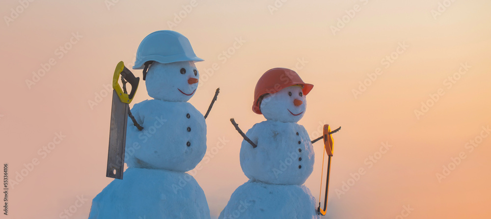 Two snow men builder in building helmet hold saw. Snowman in hard hat ...