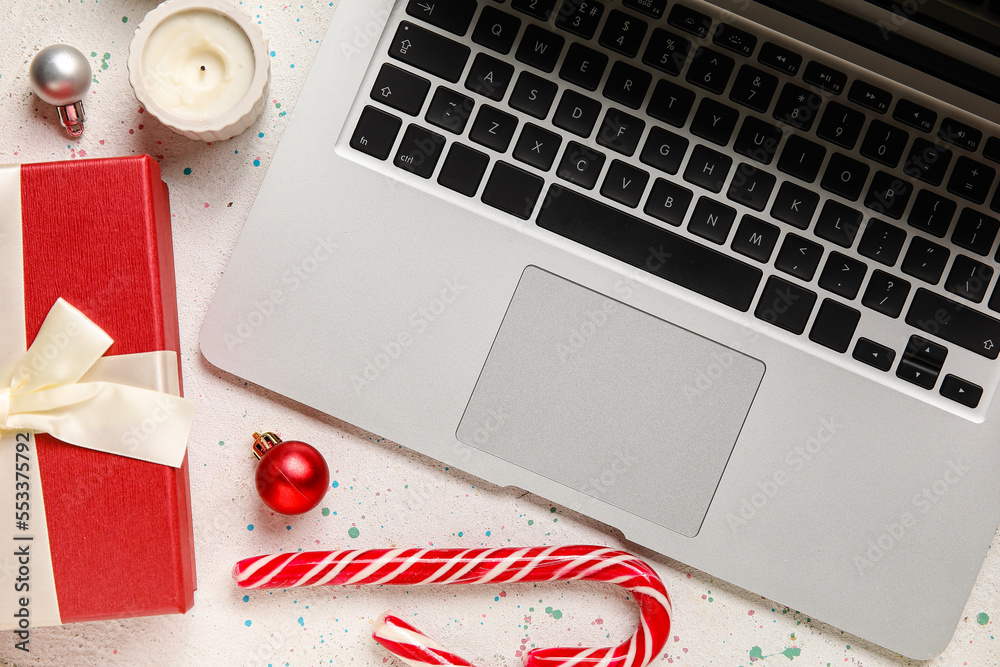 Laptop with Christmas balls, candle, gift and candy cane on grunge ...
