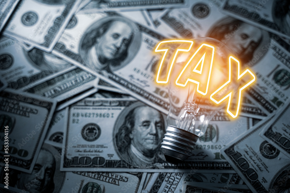 Light bulb, Tax word on business background and tax concept 2023 tax ...