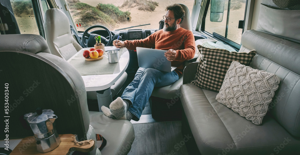 One alone man sitting and relaxing inside a camper van alternative home ...