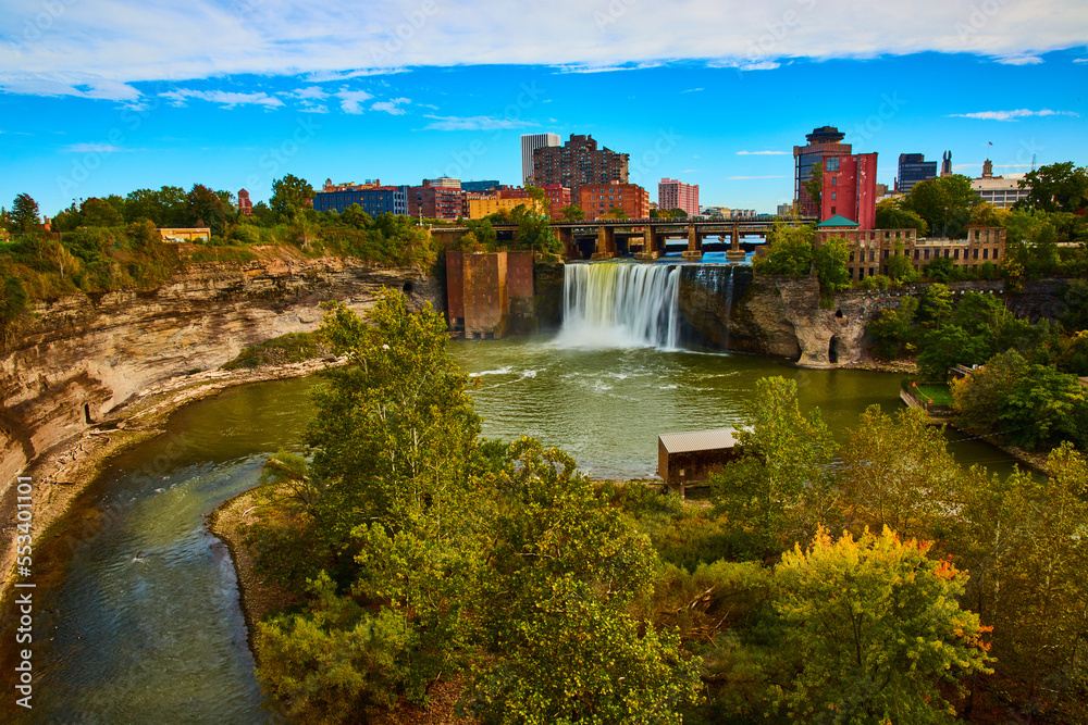 Rochester skyline along river and cliffs with waterfall pouring past ...